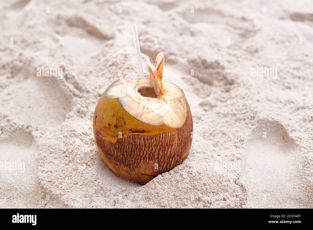 Fresh coconut on the beach with straw ready for drink. Tropical ...
