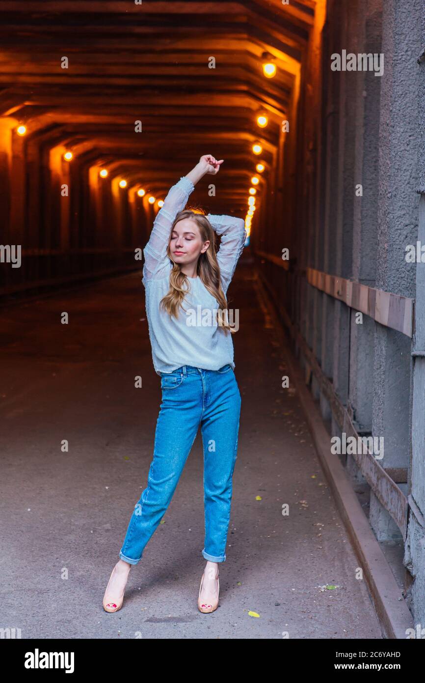Young girl standing in a tunnel with lights Stock Photo - Alamy