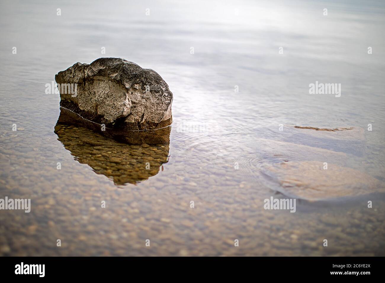 one rock washed by water on the shallow bank Stock Photo - Alamy