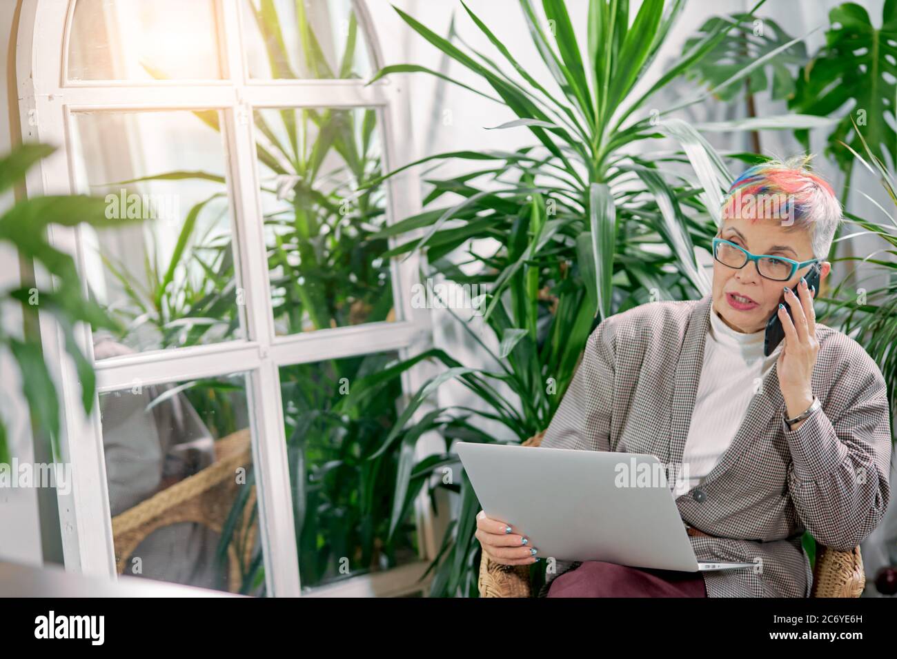 Strict middle-aged business lady boss working in office talking on ...