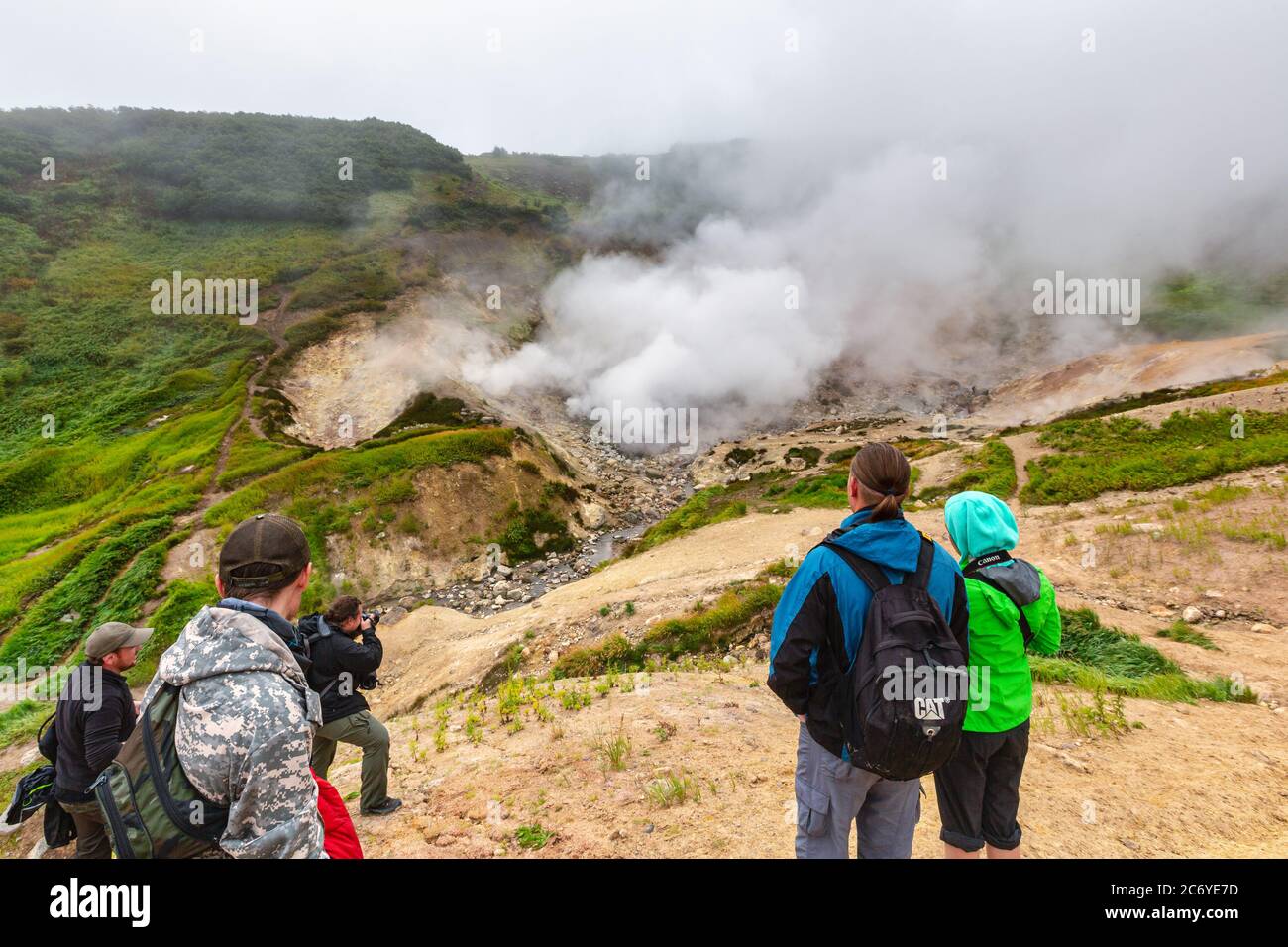Group of tourists and travelers watching beautiful volcanic landscape ...