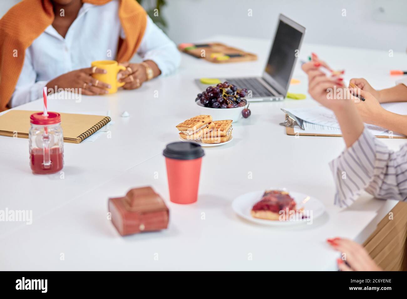 Office workers sit on table during break time, leisure time. Cup of ...