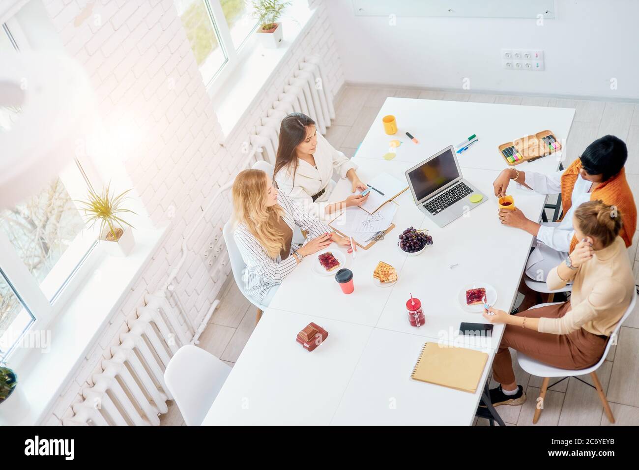 Four women sitting close together hi-res stock photography and images ...