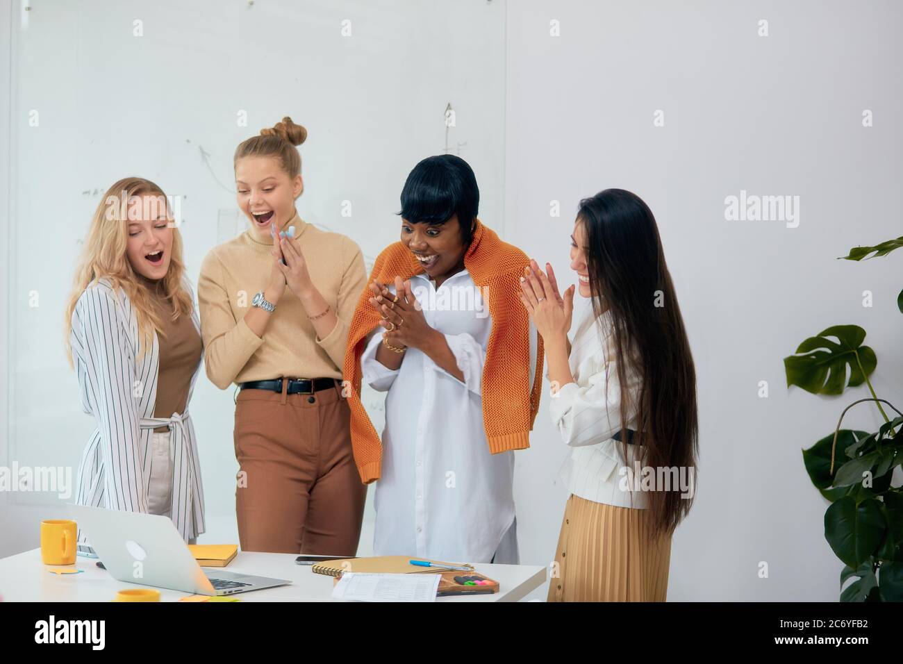 Surprised women in casual wear in office together, in shock with opened ...