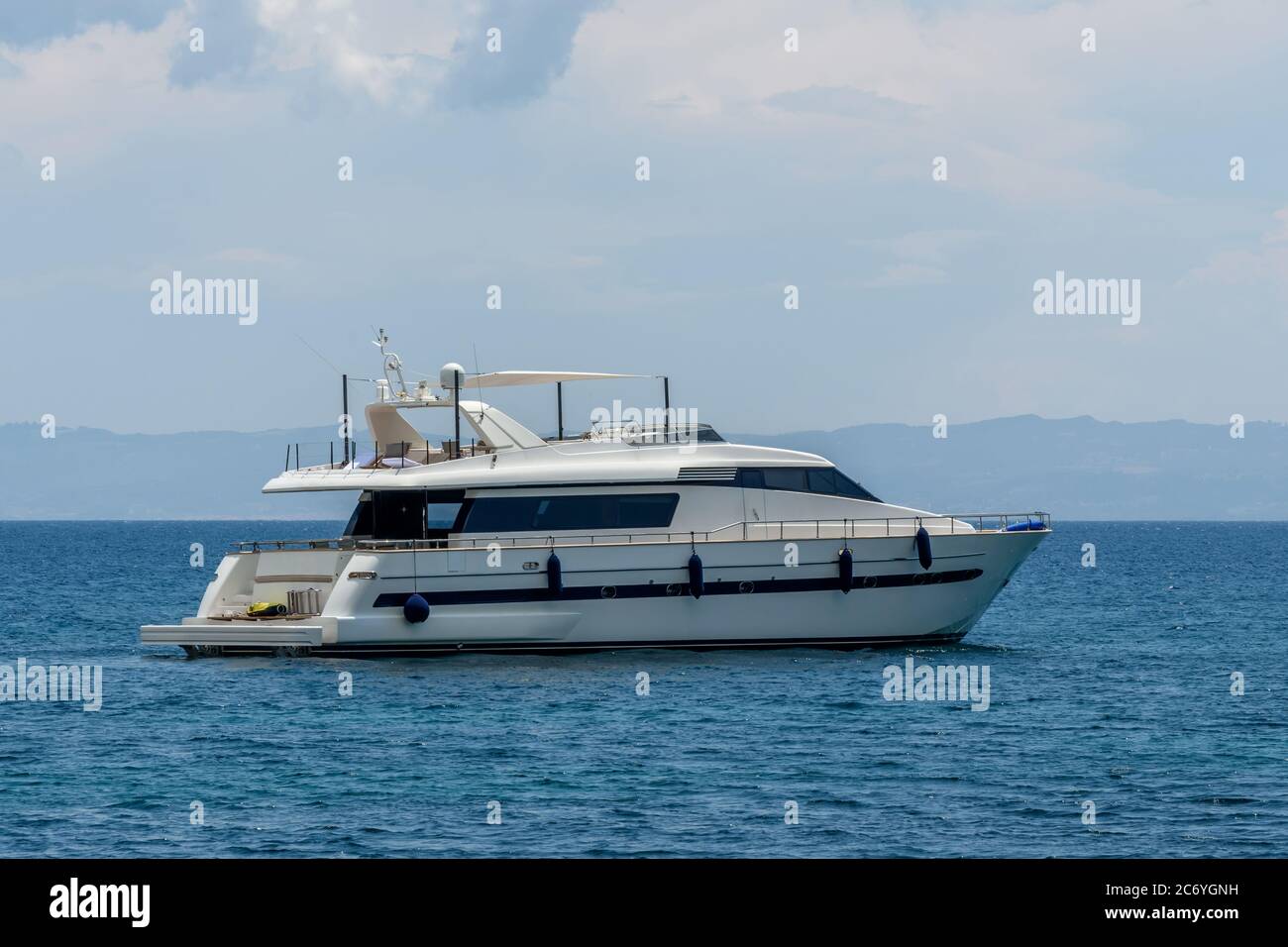 Luxury private motor yacht under way on tropical sea with bow wave ...