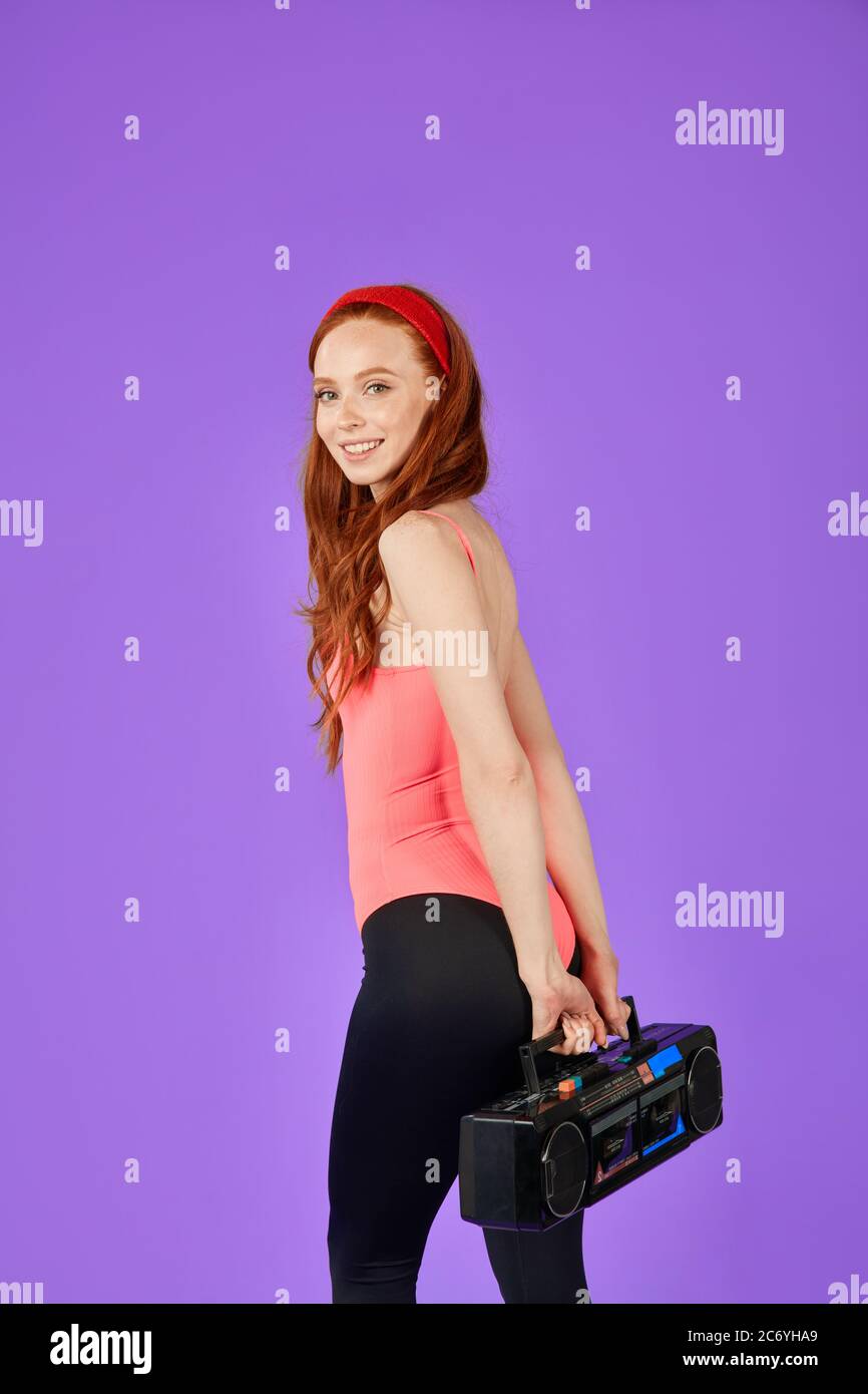 beautiful fit ginger female model with curly long hair posing for retro ...