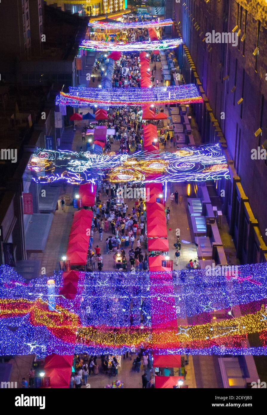 Aerial view of a night market decorated with colorful LED lights that ...
