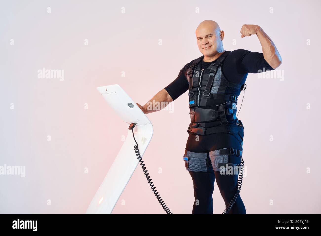 strong cheerful man in EMS suit showing his biceps while training ...