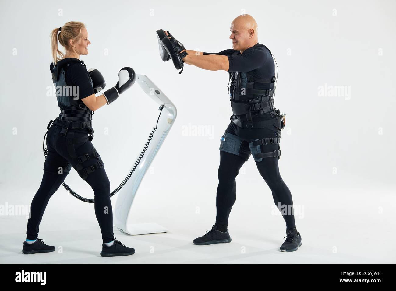 happy female kickboxer wearing ems suit and preparaing to kick. full ...