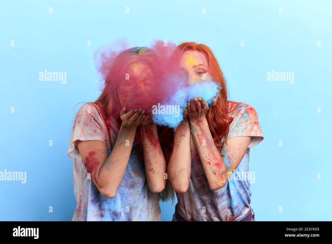 happy funny girls blowing colourful powder during the holi festival ...