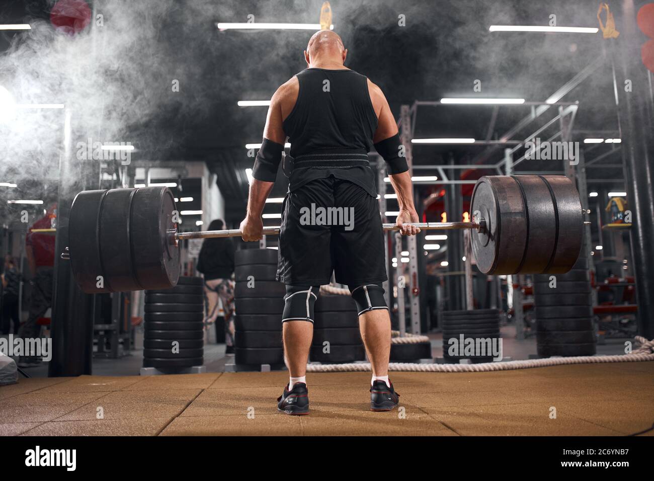 Strong powerful powerlifter standing with back towards camera, wearing ...