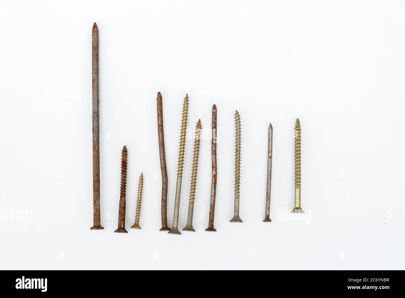 rusty nails are laid out in order from large to small on a white ...