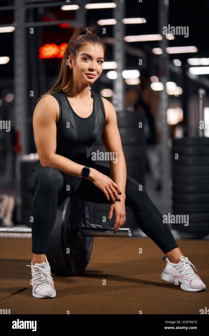 Beautiful active woman with long straight hair, looking at camera with ...