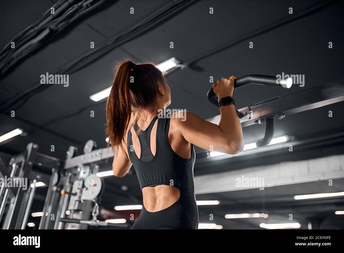 Sporty active powerlifter pulling up in modern gym studio, pumping ...