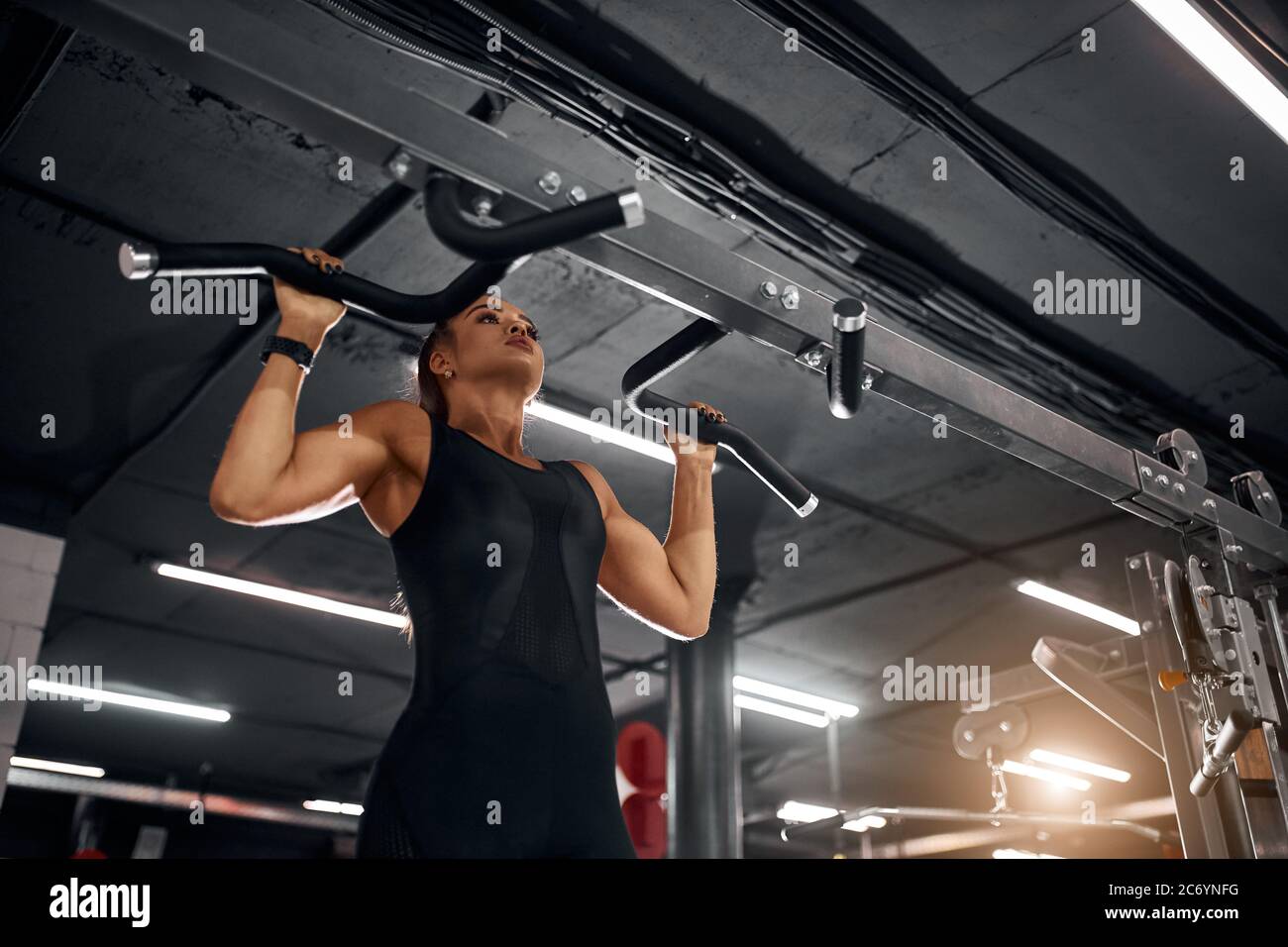 Attractive sporty female powerlifter training in modern gym, pumping ...