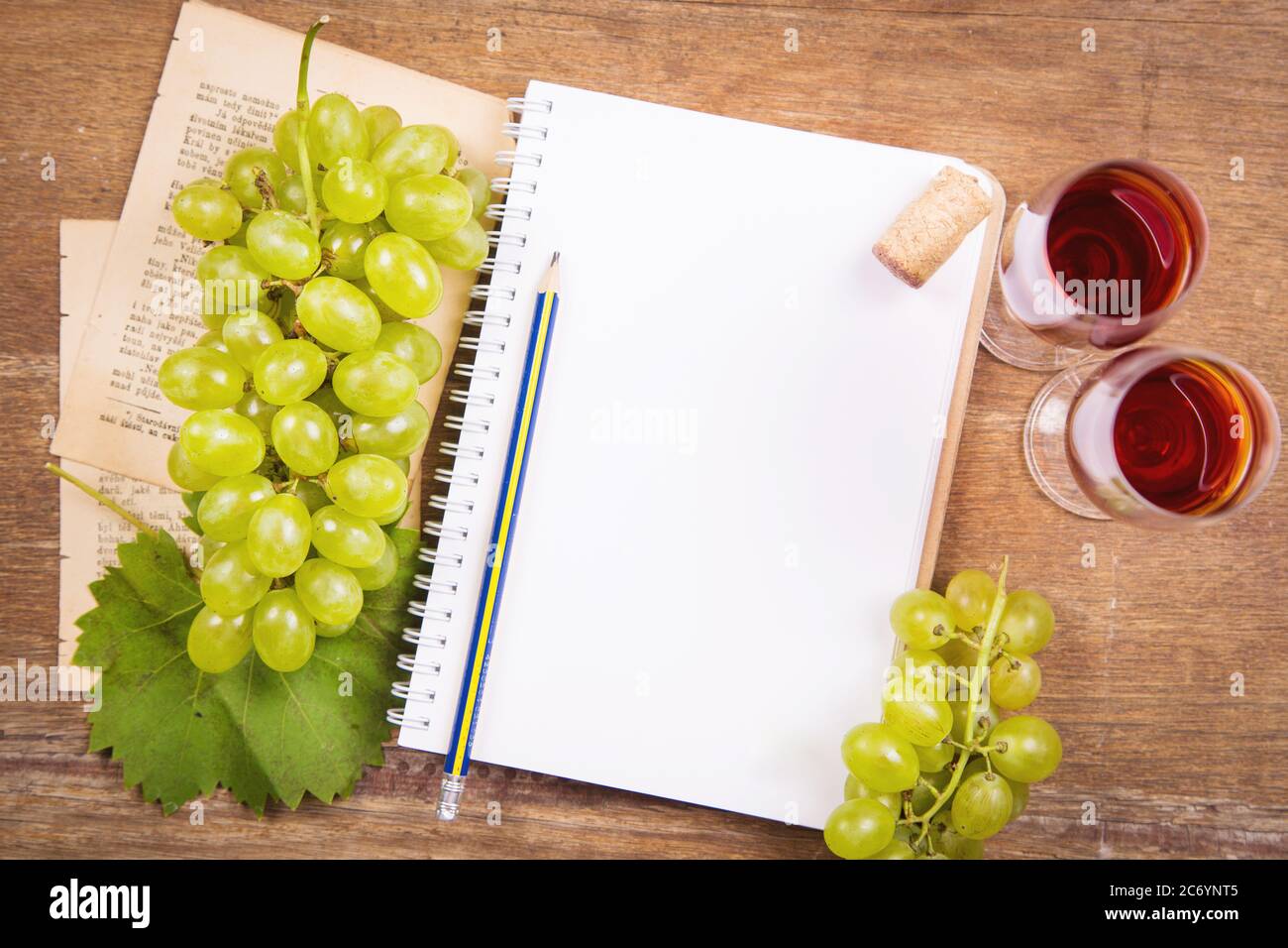 green grape with red wine,empty notebook,cork on wooden background ...