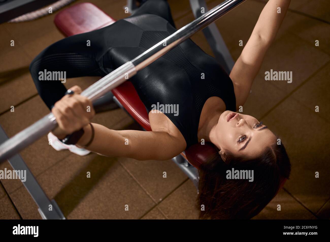 Powerlifter with strong arms lifting weights in modern fitness club ...