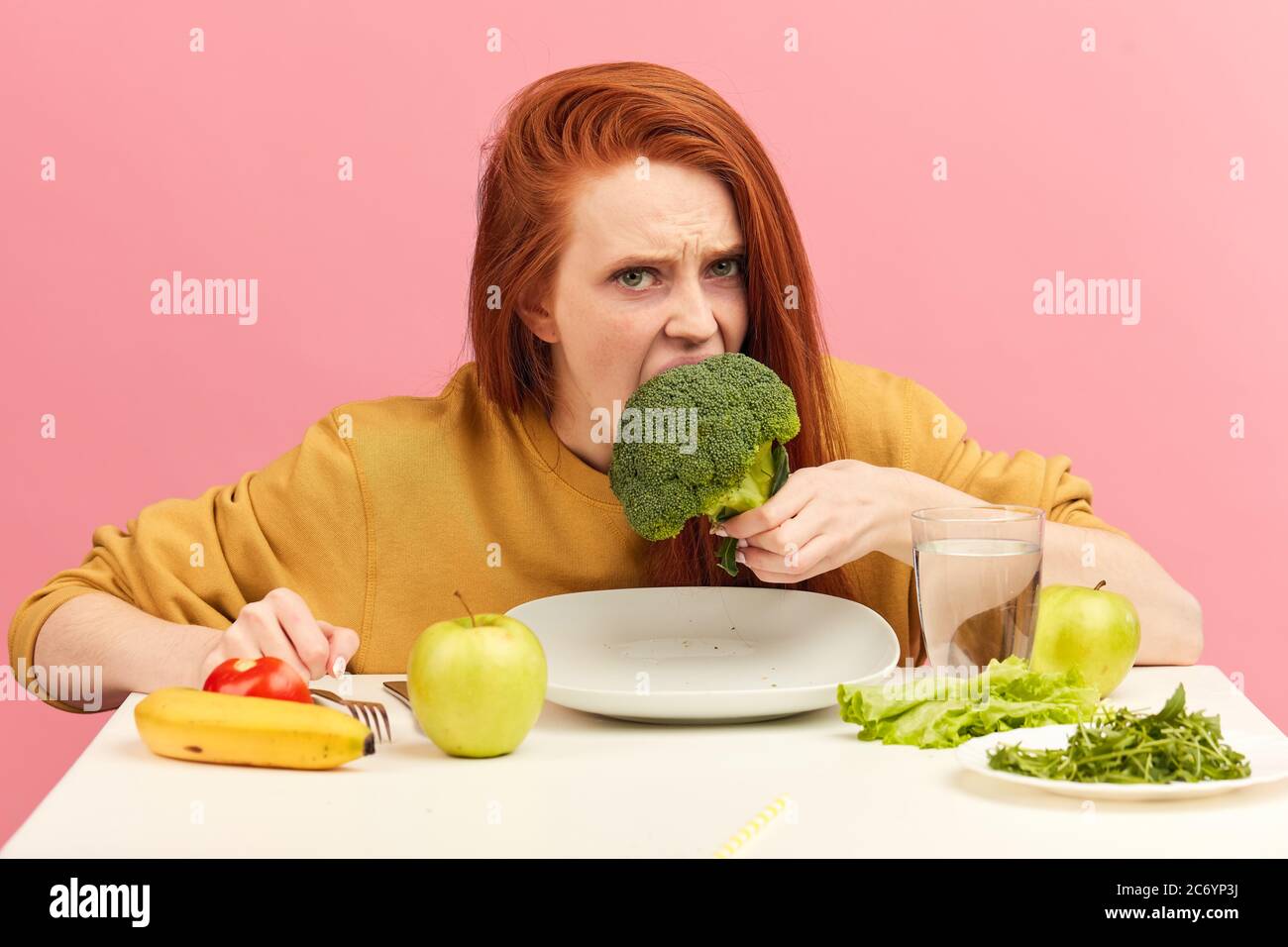 Sad red-haired woman in bad temper keeping strict vegetarian diet being ...