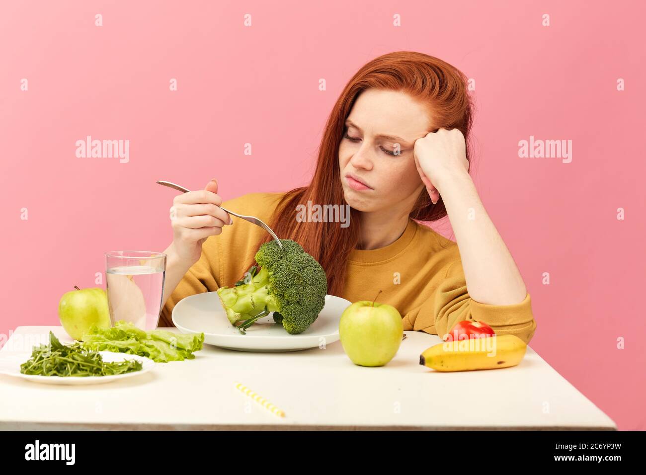 Sad red-haired woman in bad temper keeping strict vegetarian diet being ...