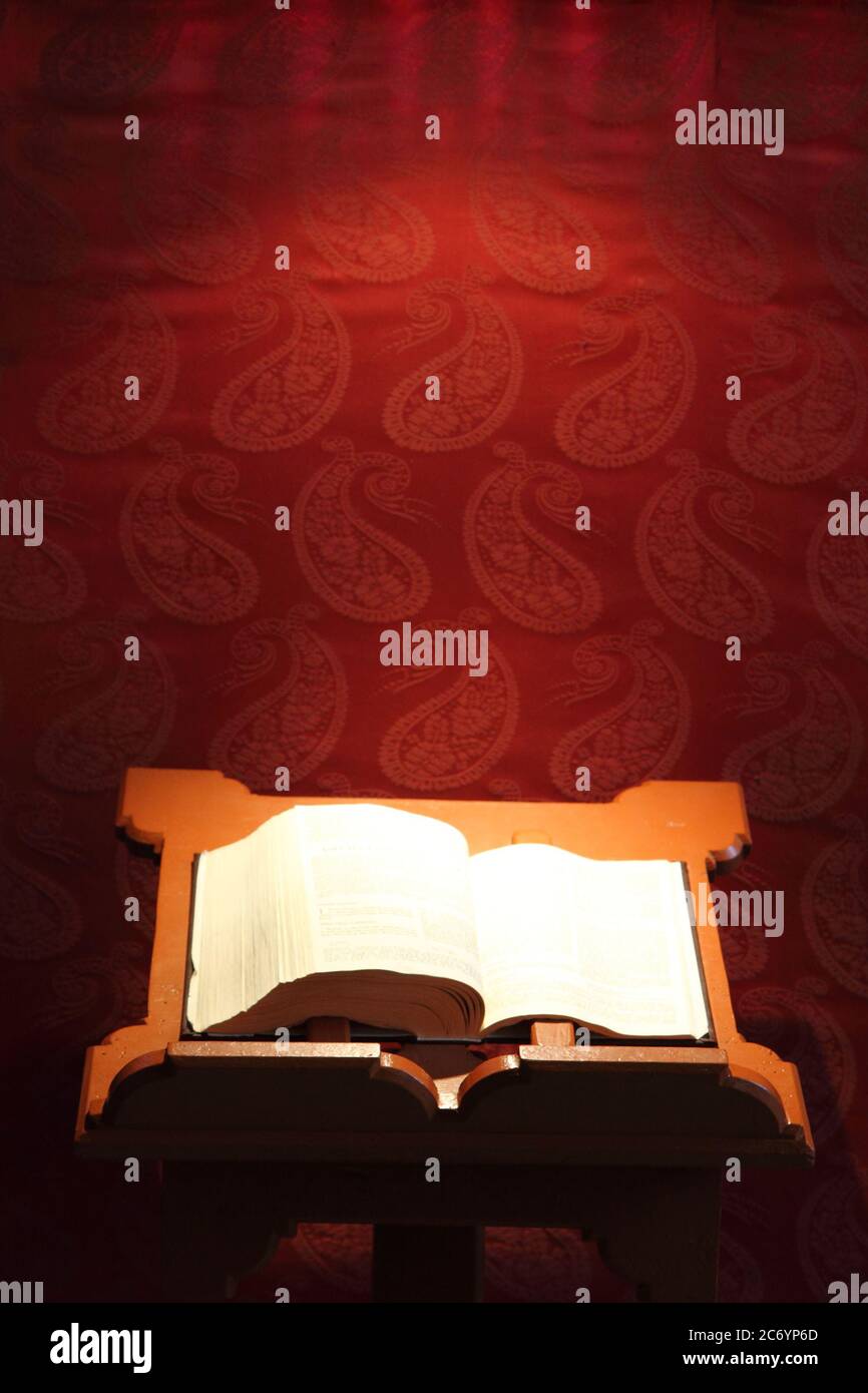 old open bible on the red background Stock Photo - Alamy