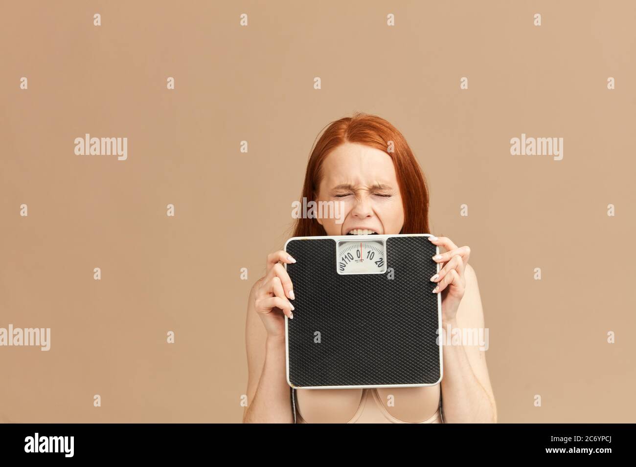 Diet and weight, young woman sitting on her haunches on a scale Stock ...