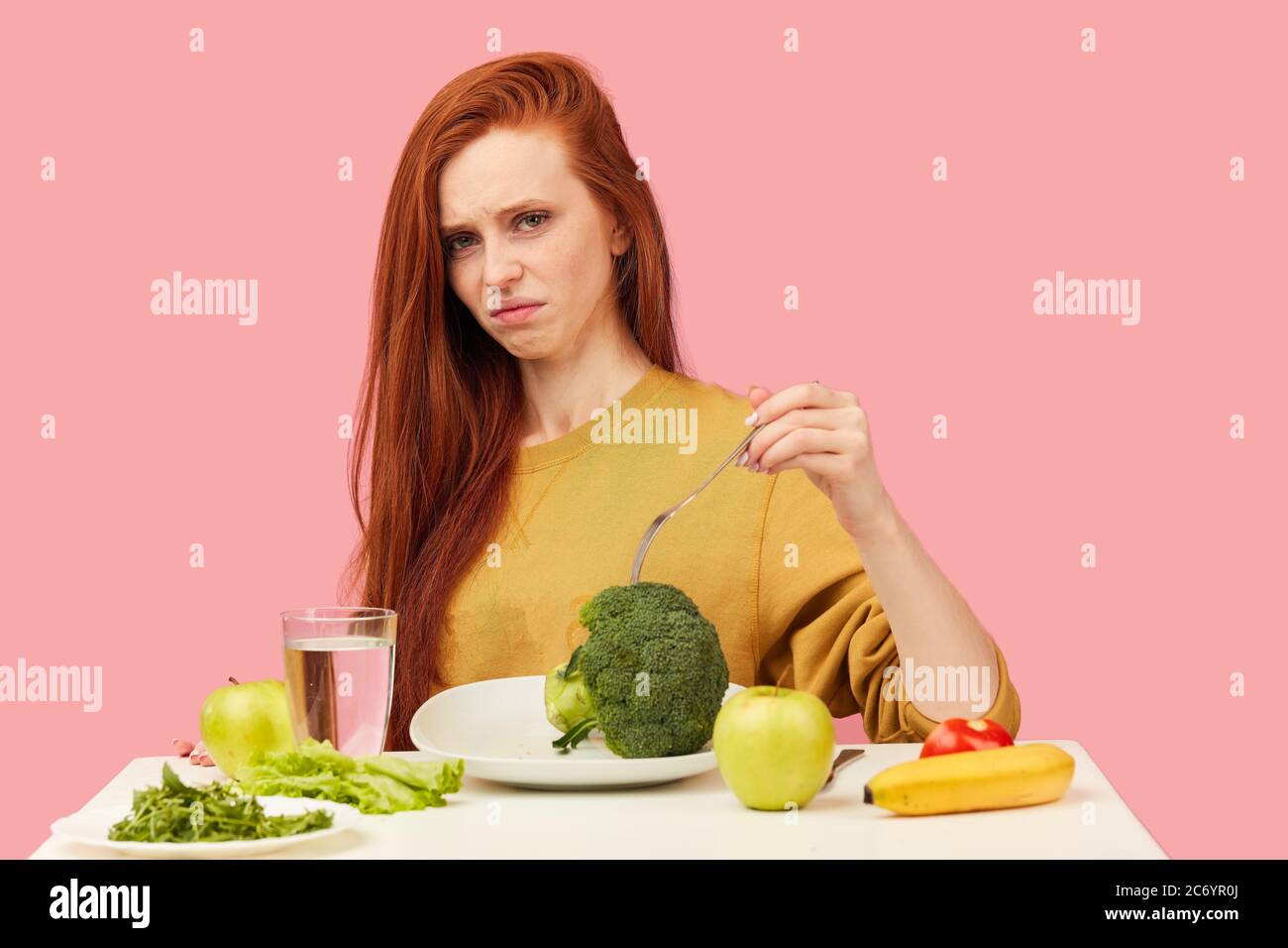 Sad red-haired woman in bad temper keeping strict vegetarian diet being ...