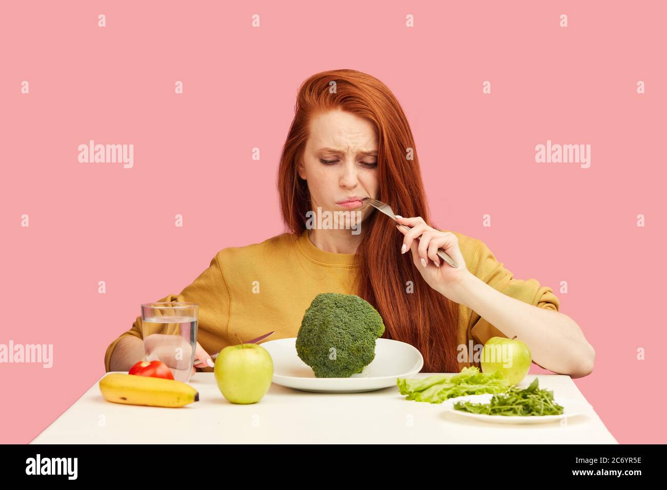 Red-haired woman in bad temper keeping strict vegetarian diet being ...