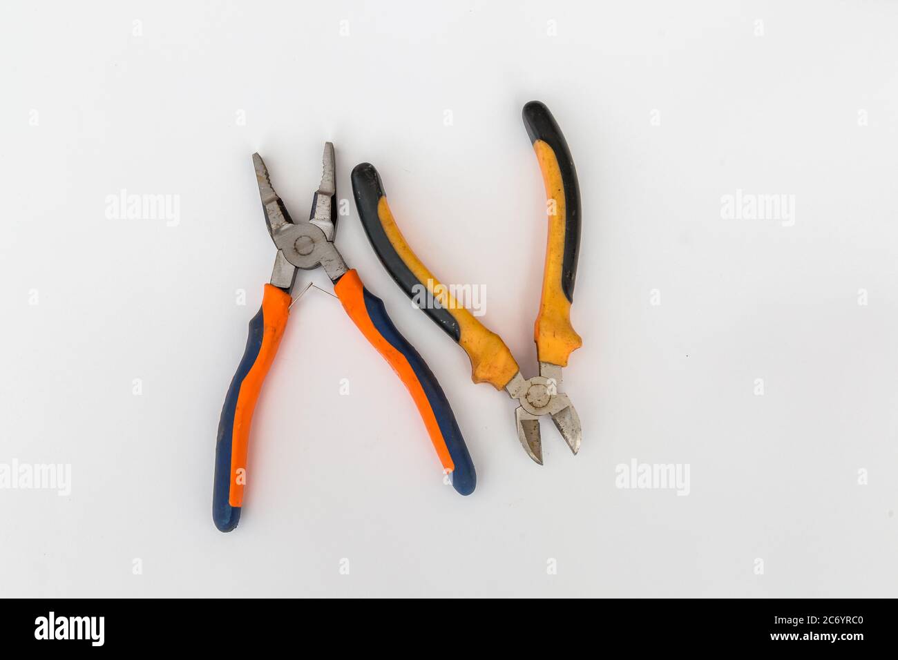 Wire cutters and pliers with orange black handles on white background ...