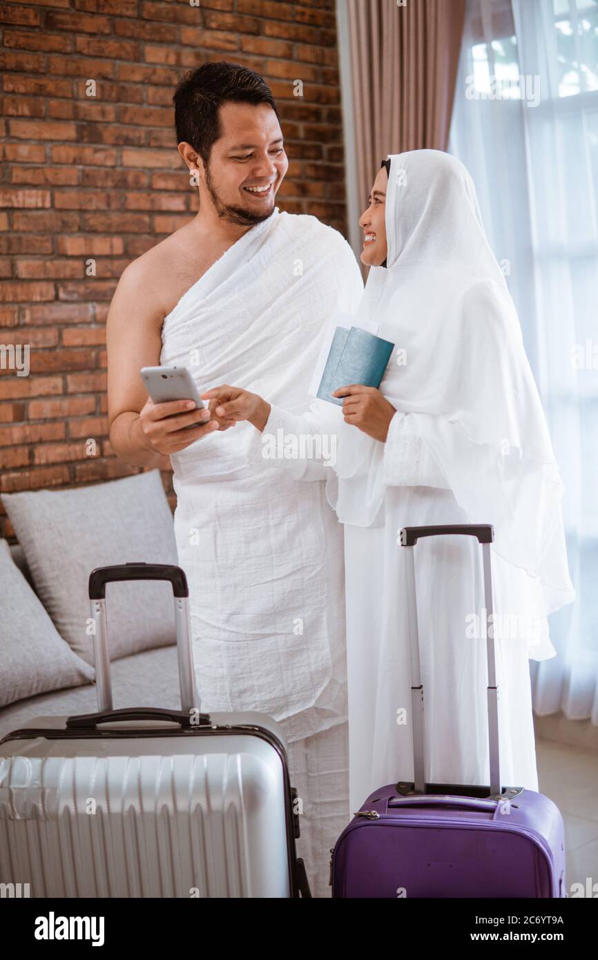 portrait of muslim couple making a phone call while umrah and hajj ...