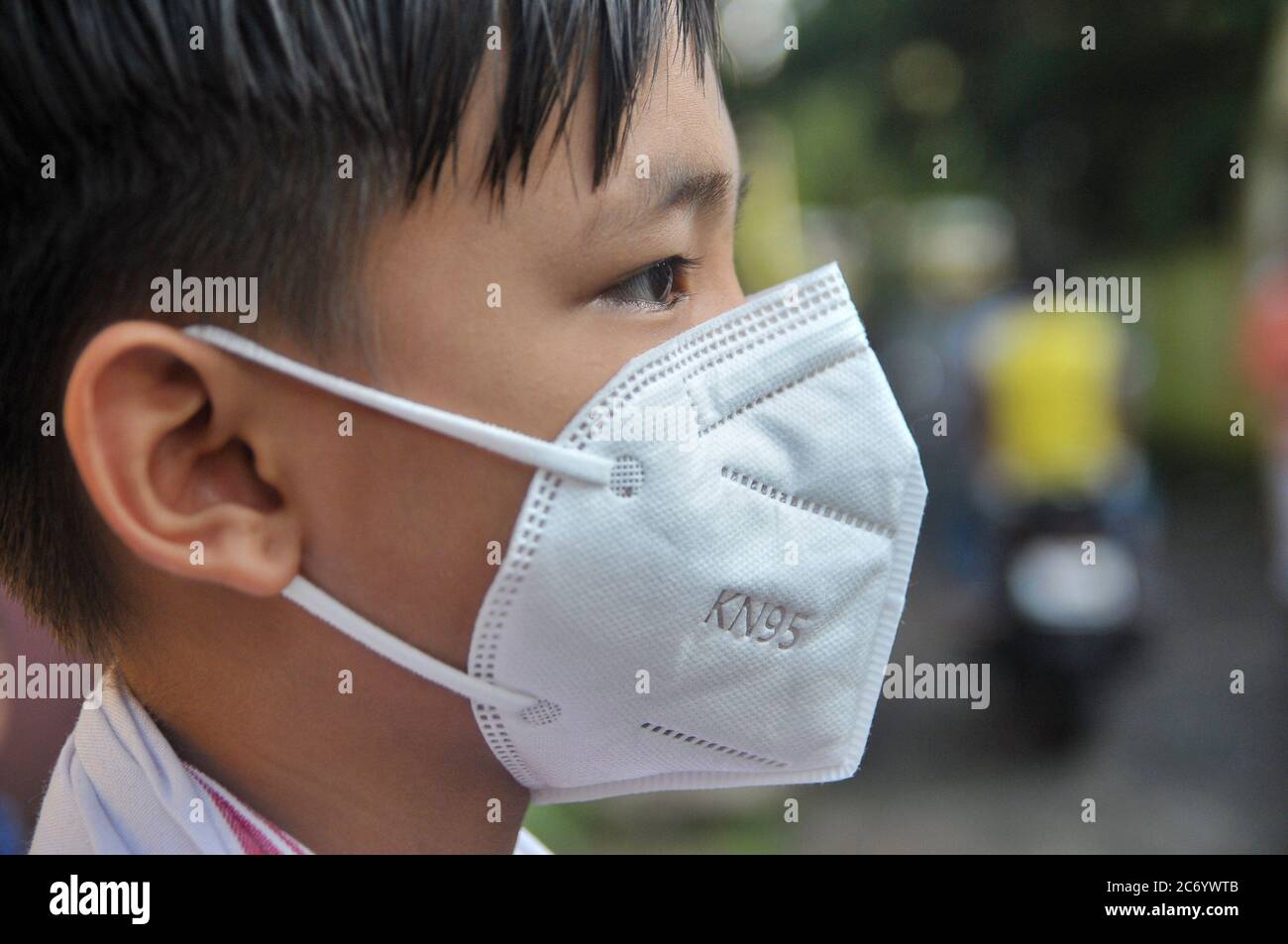 A young boy wearing a N95 mask as a preventive measure against the ...