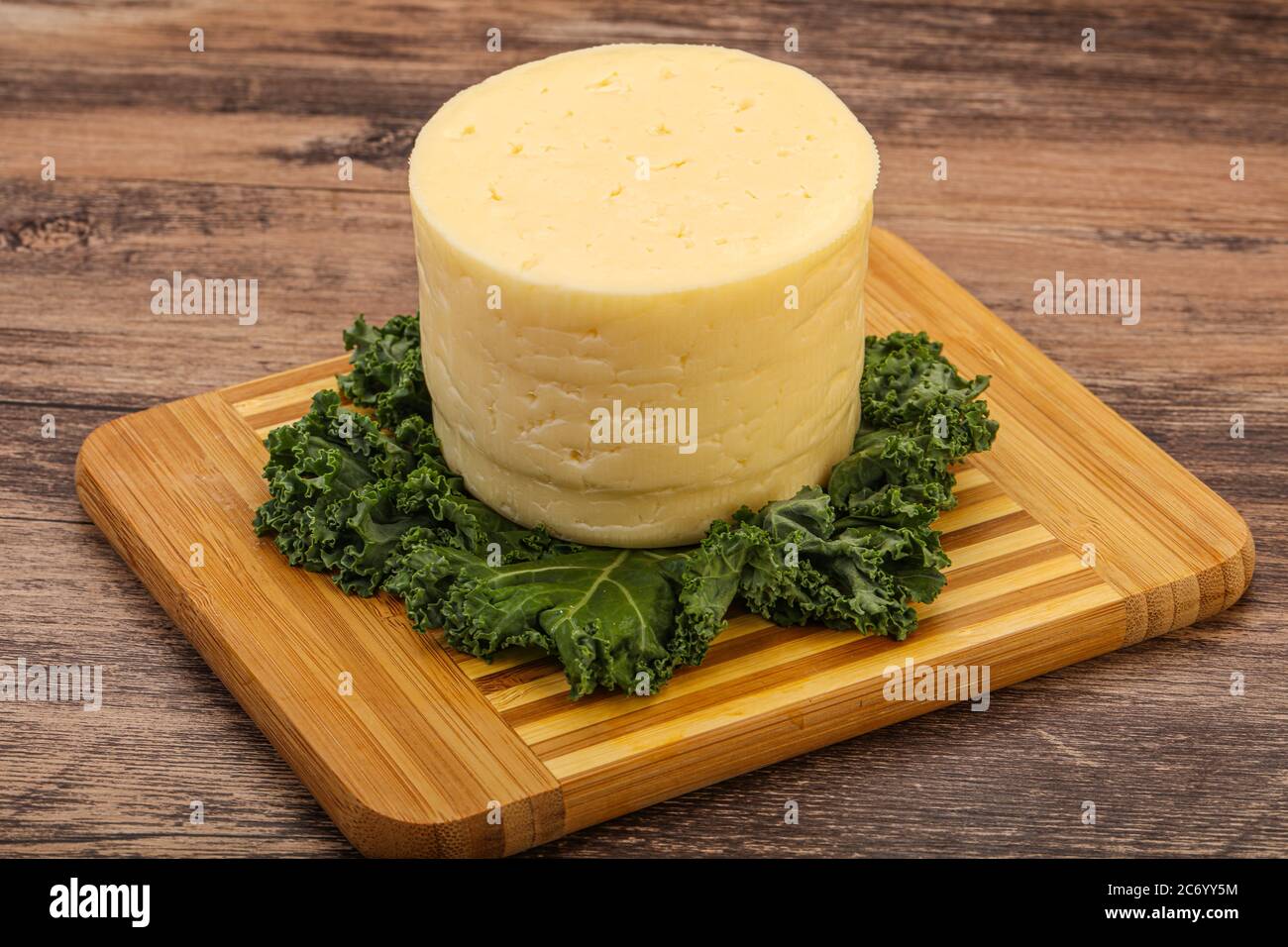 Yellow round dairy soft cheese piece Stock Photo - Alamy