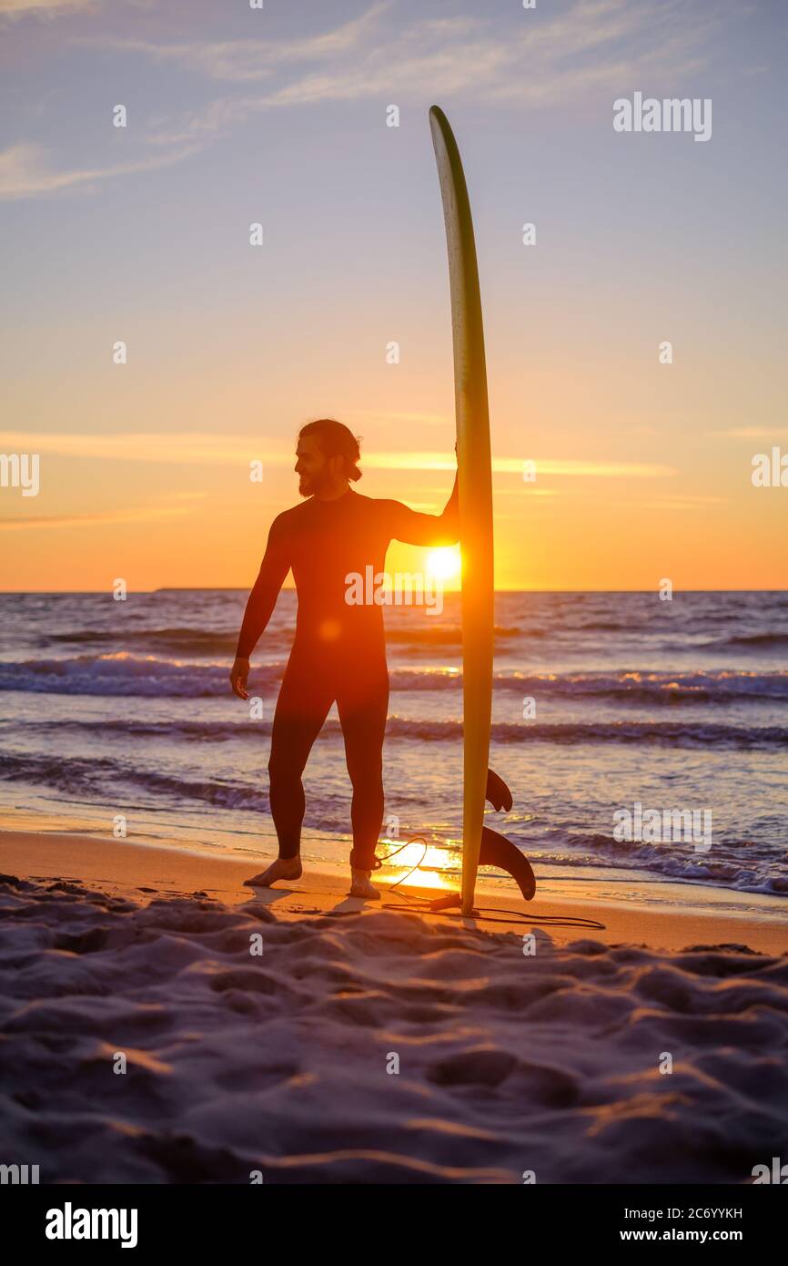 Bearded surfer on beach during sunset Stock Photo - Alamy
