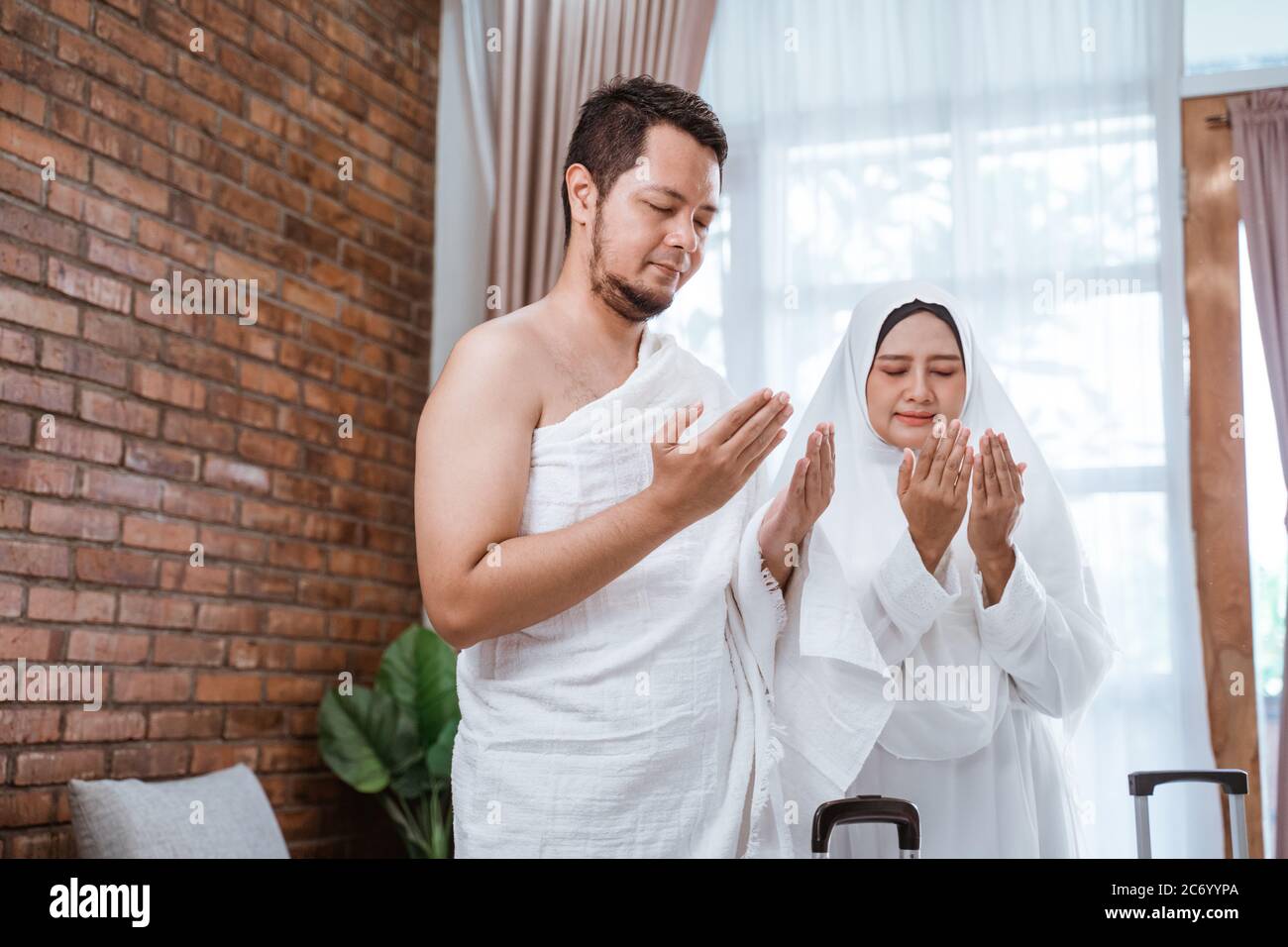 Muslim couple praying open their arm wearing ihram Stock Photo - Alamy