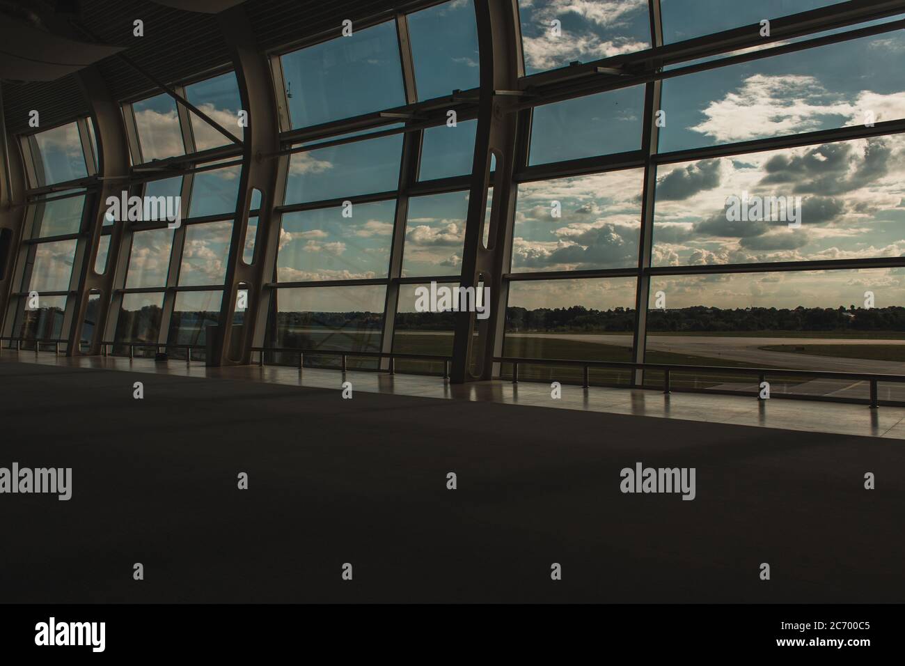 Airport windows with cloudy sky and airfield at background in ...