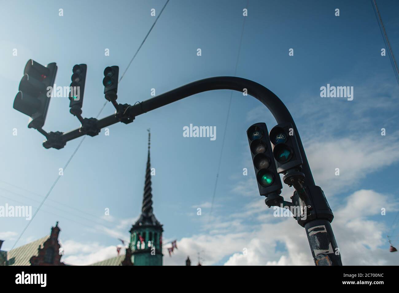 Low angle view of traffic lights with cloudy sky at background on urban ...