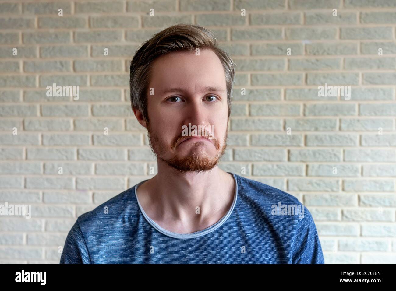 Facial expressions sad of young red bearded man Stock Photo - Alamy