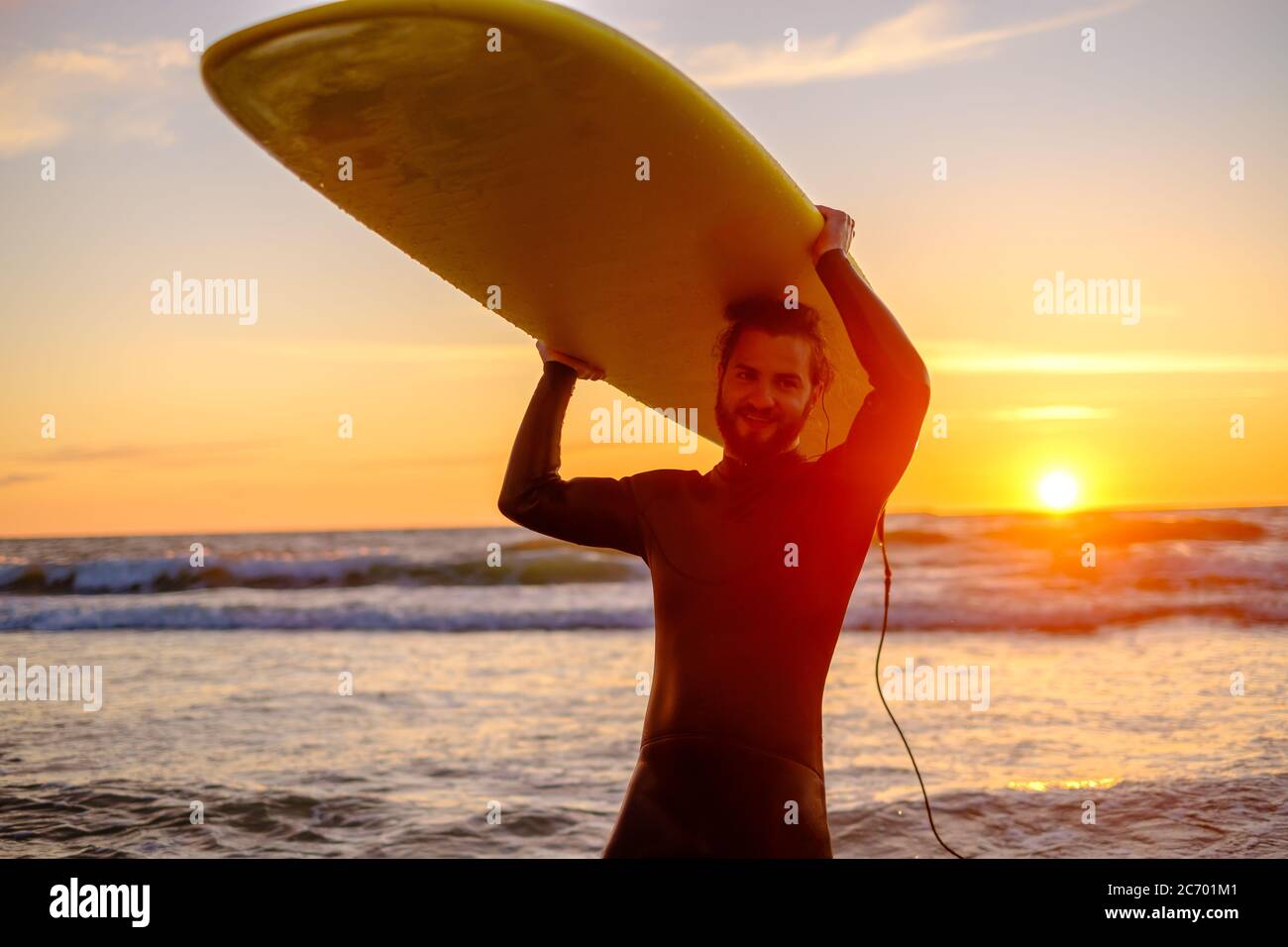 Happy bearded surfer in sundown Stock Photo - Alamy