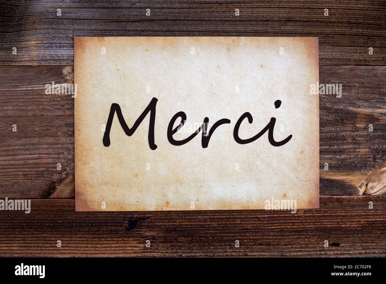 Old Paper, Merci Means Thank You, Wooden Background Stock Photo - Alamy
