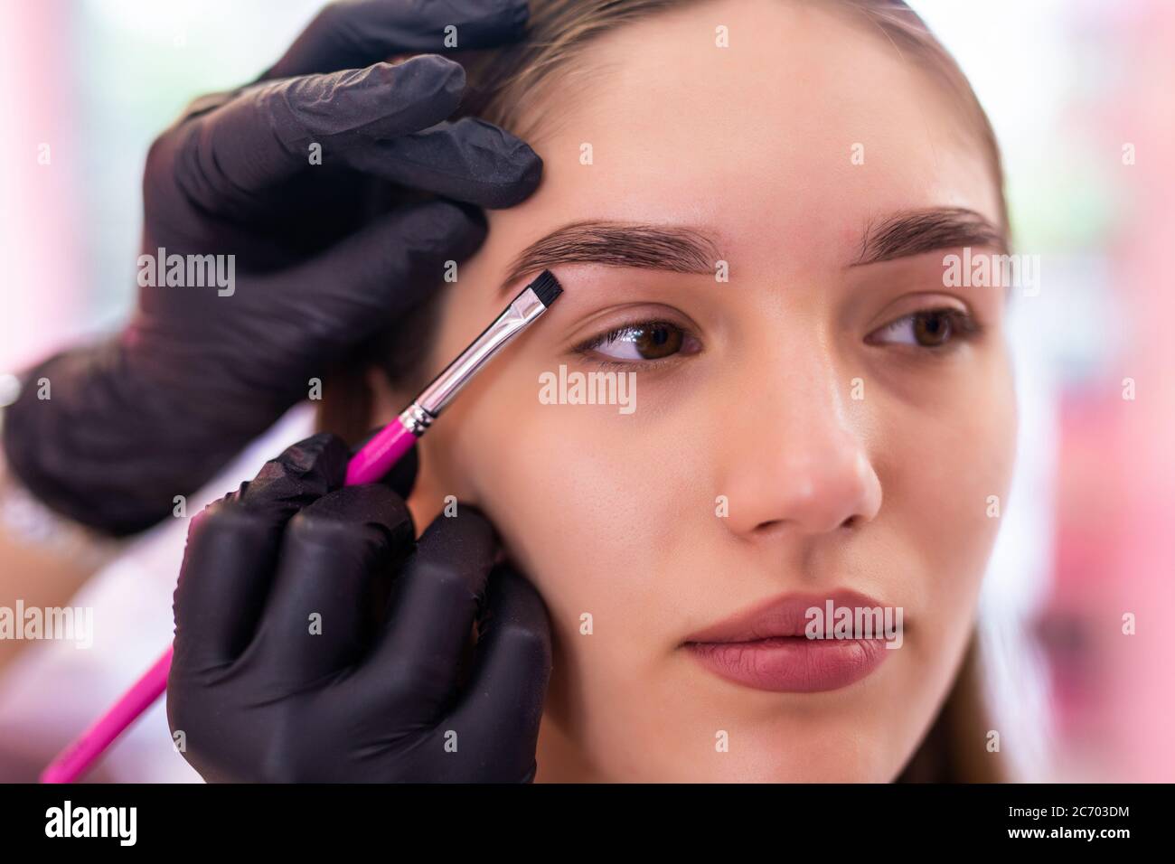 Beautiful young woman gets eyebrow correction procedure. Young woman ...