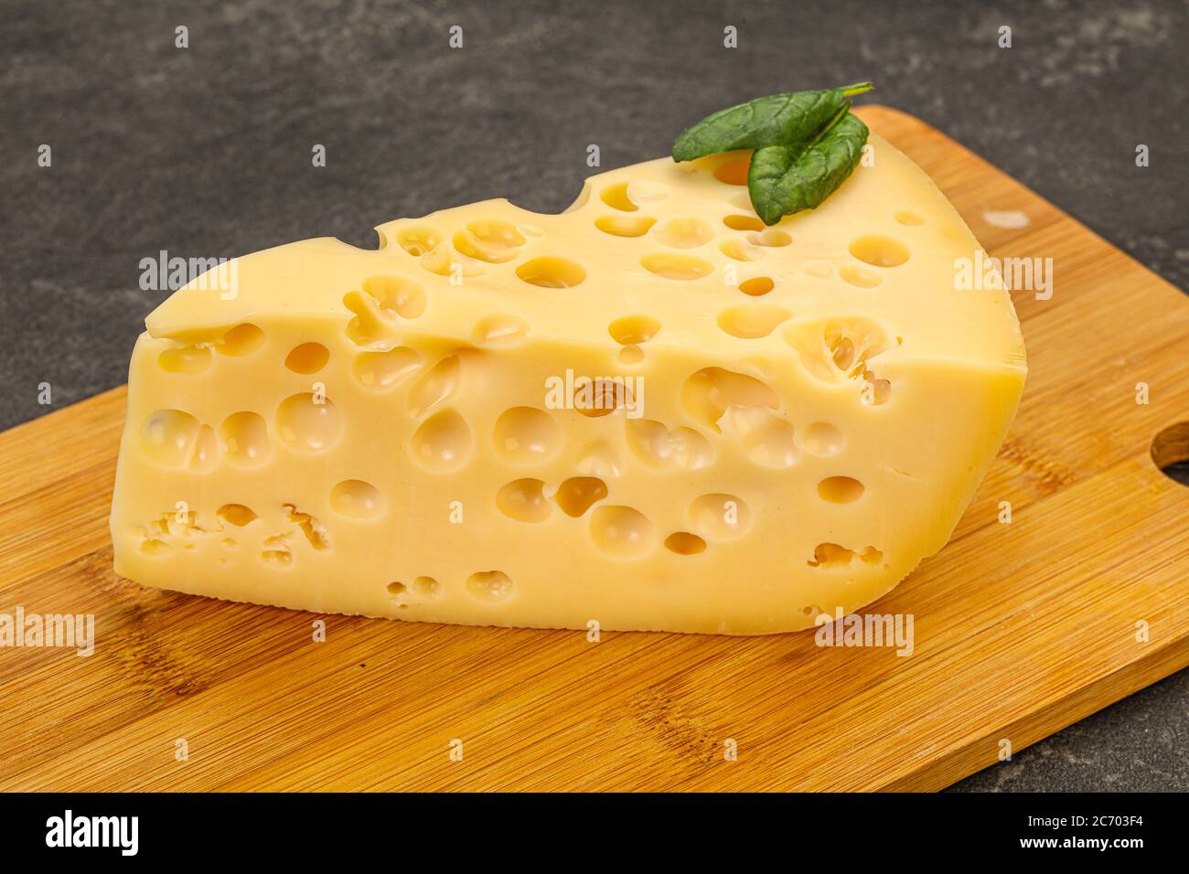 Maasdam cheese - dairy yellow triangle with holes Stock Photo - Alamy