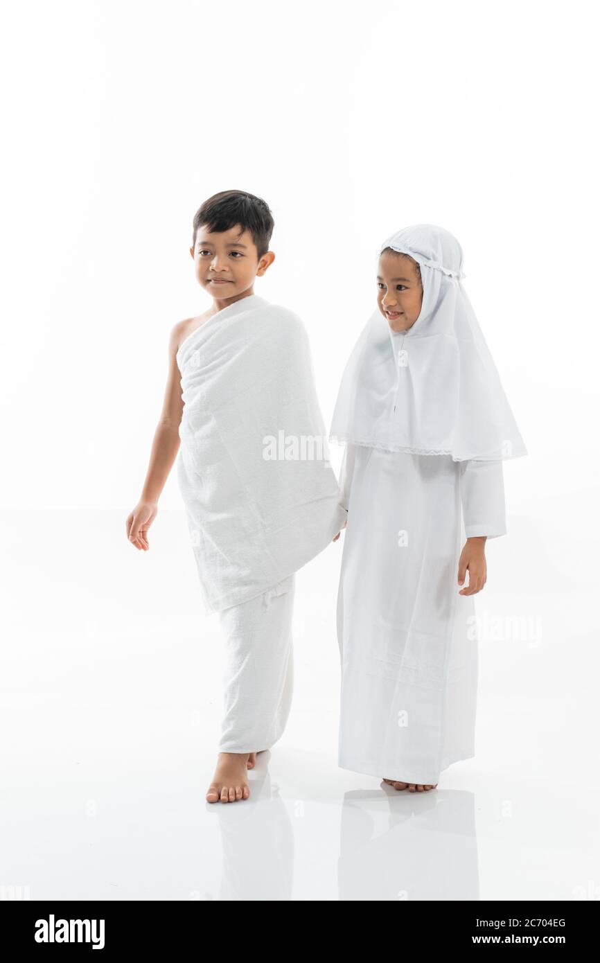cute little kid wearing muslim ihram clothes and dress holding hand and ...