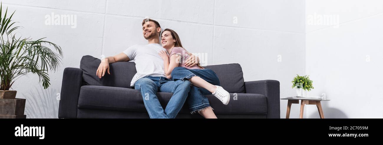 smiling girlfriend and boyfriend hugging at home with air conditioner ...