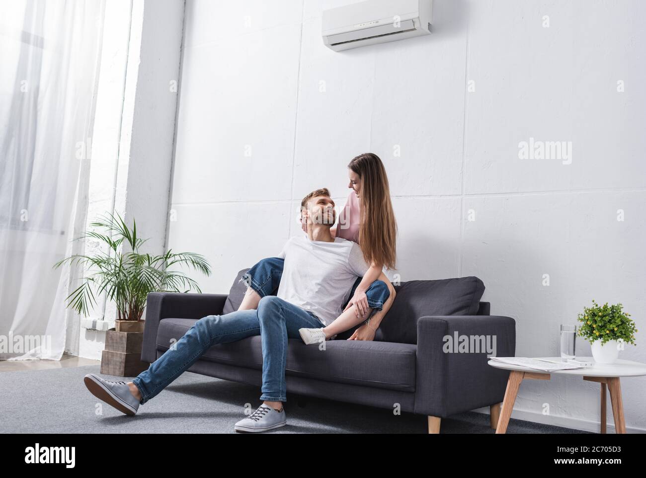 happy emotional couple hugging at home with air conditioner Stock Photo ...