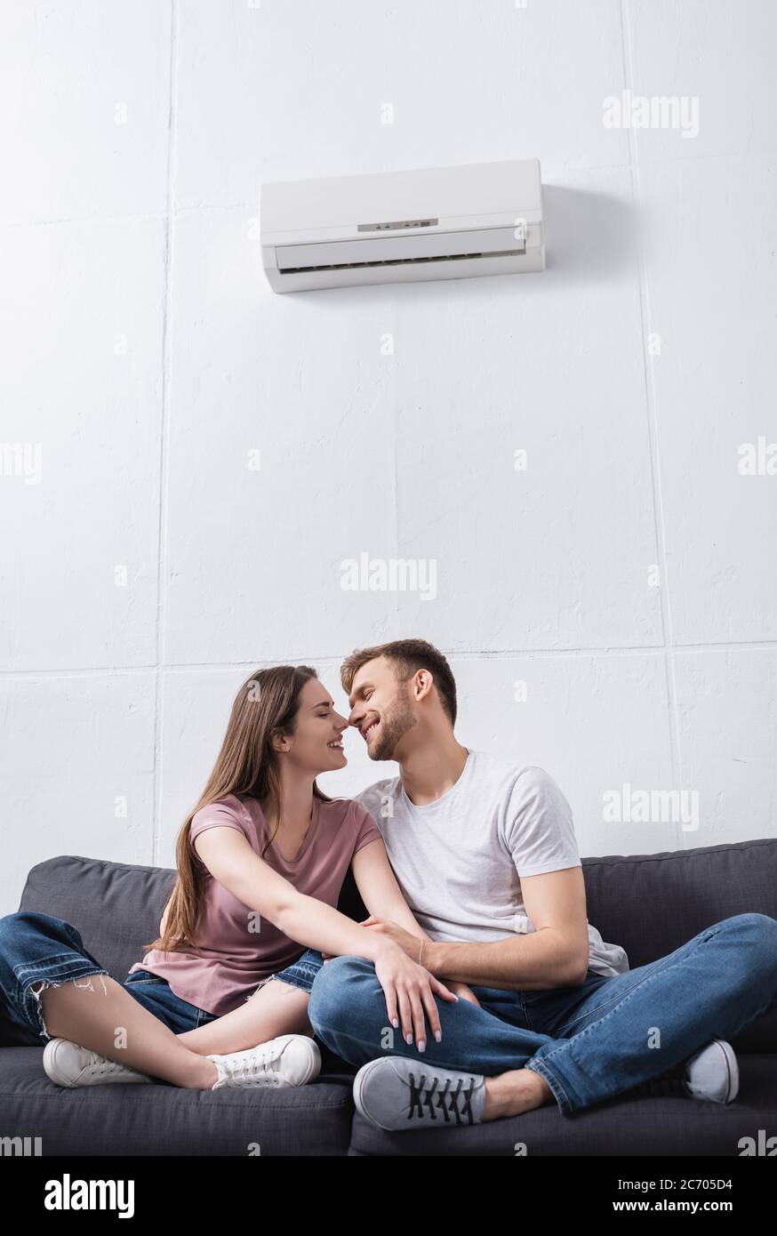 positive girlfriend and boyfriend hugging and going to kiss at home ...