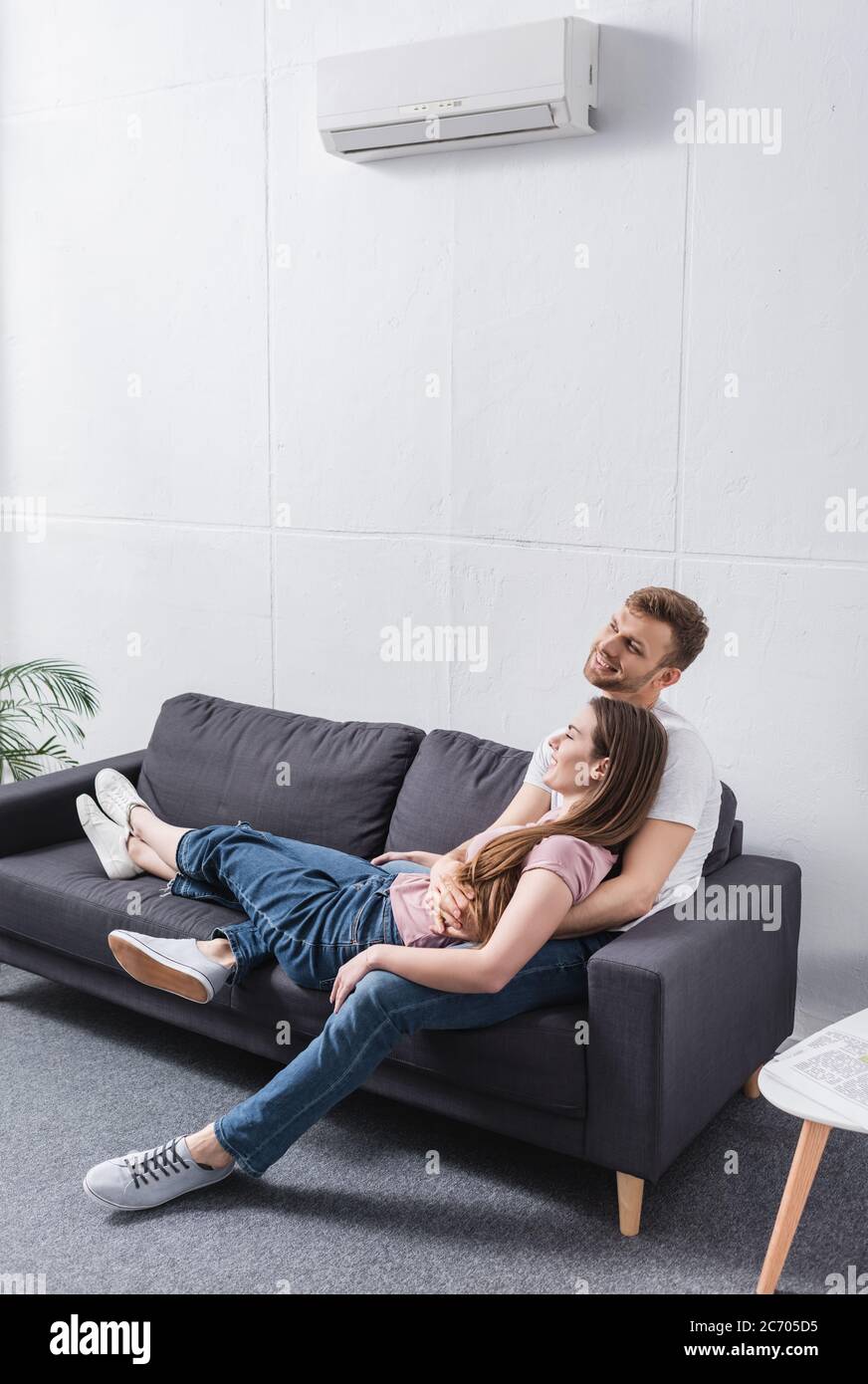 young happy couple hugging at home with air conditioner Stock Photo - Alamy