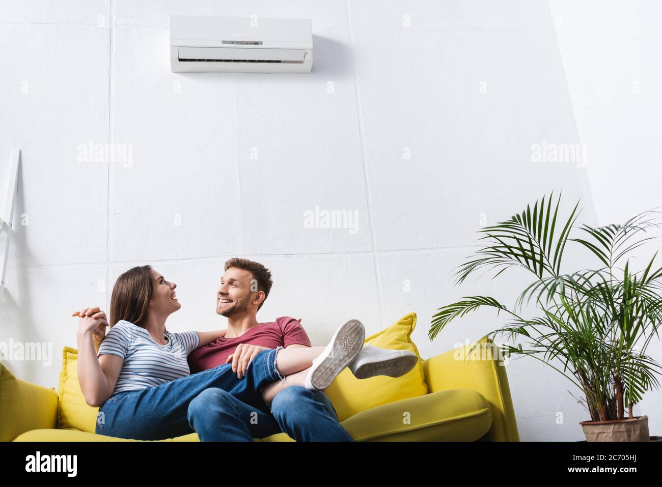 happy young couple hugging at home with air conditioner Stock Photo - Alamy