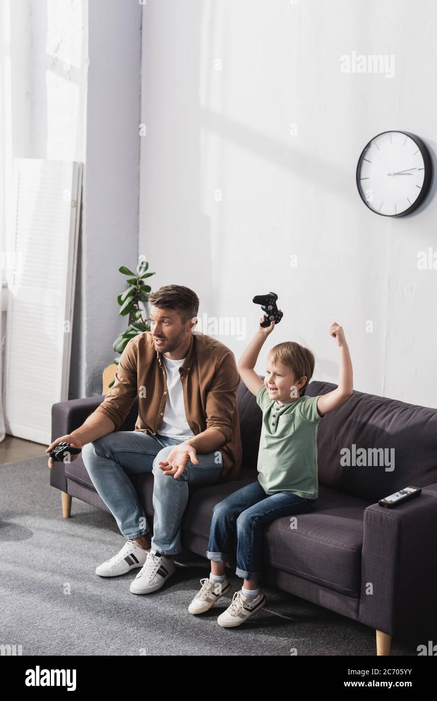 KYIV, UKRAINE - JUNE 9, 2020: happy boy holding joystick and showing ...
