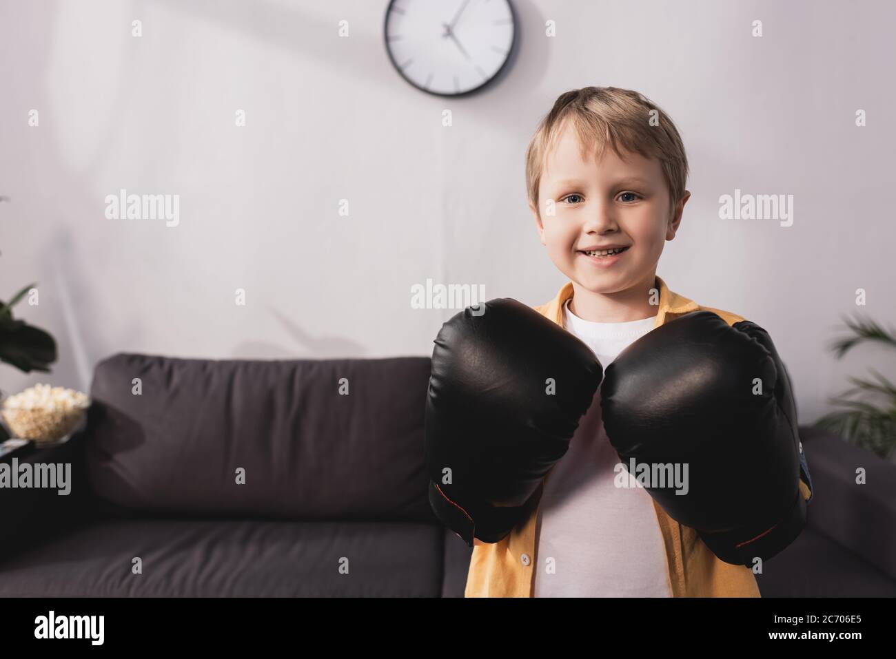 happy boy in boxing gloves smiling while looking at camera Stock Photo ...
