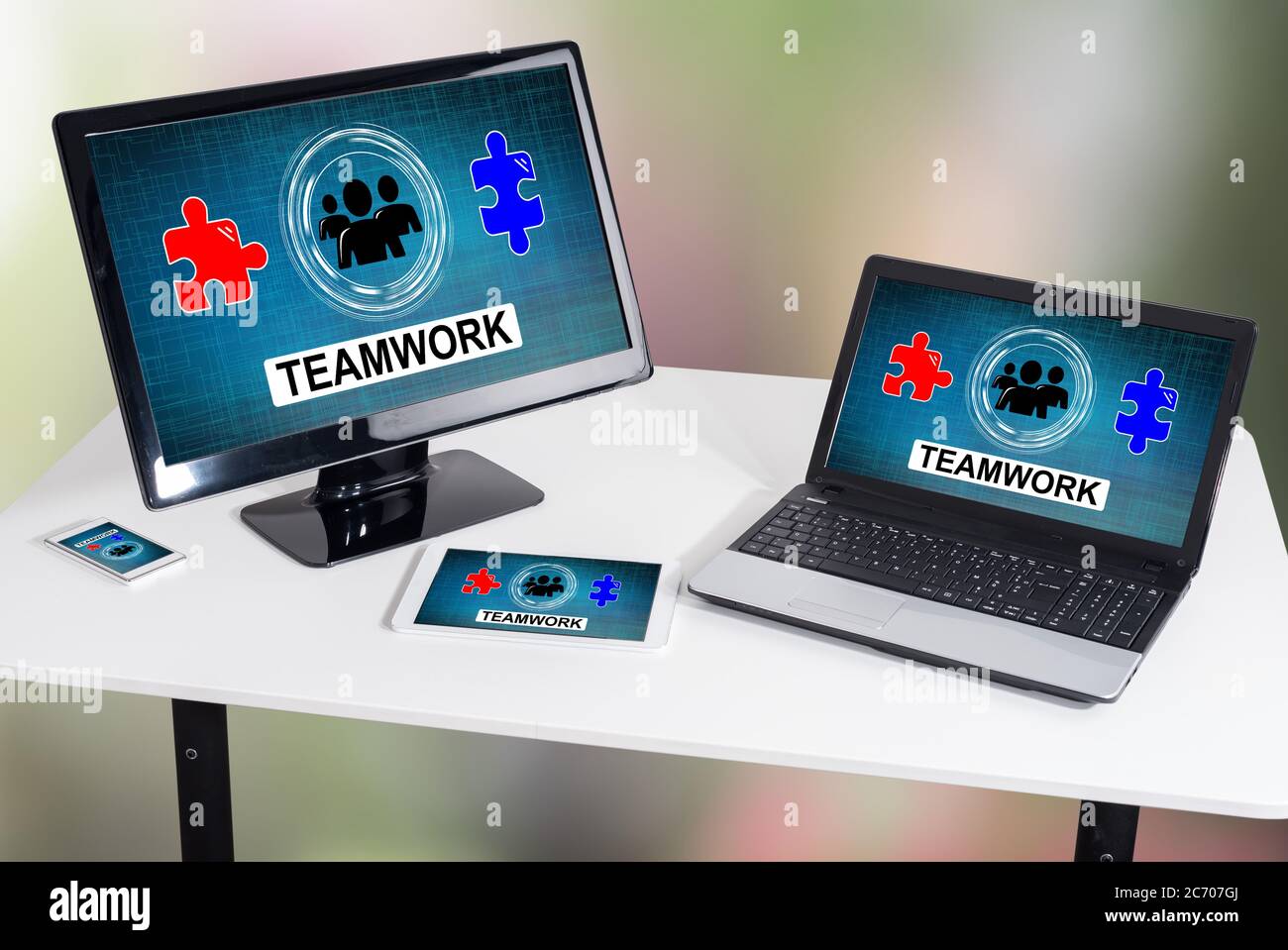 Teamwork concept shown on different information technology devices ...