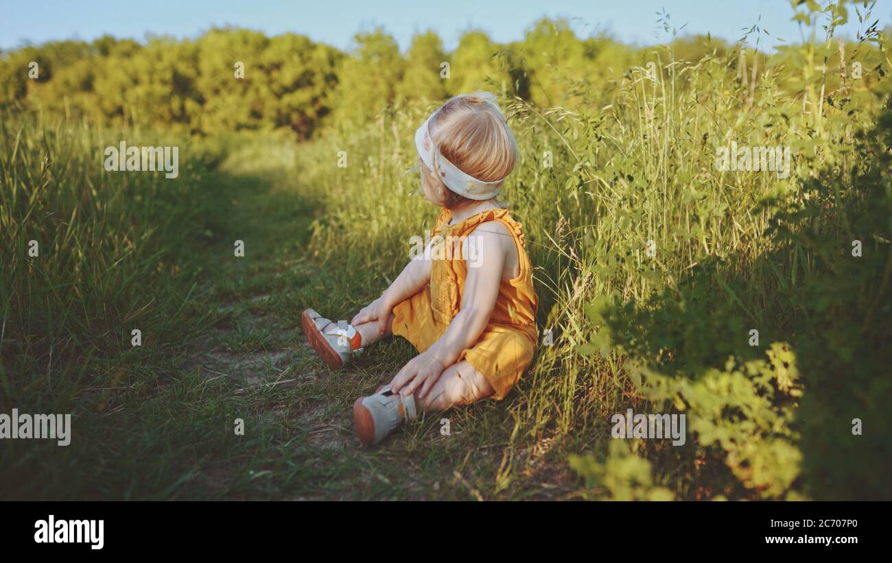Child sitting on grass baby girl playing outdoor family summer ...